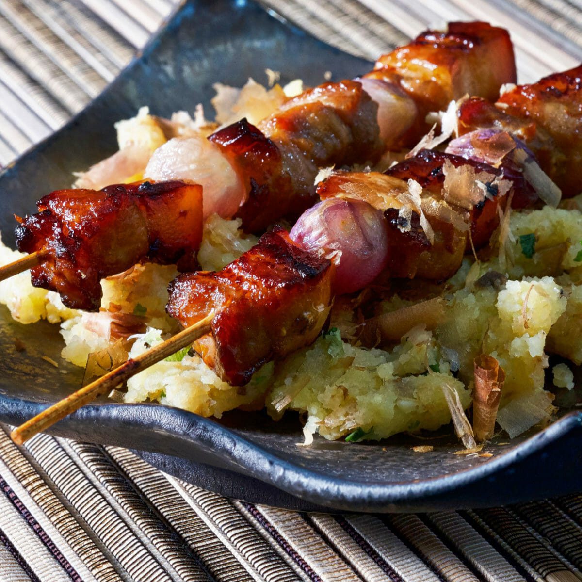 Marinated pork belly skewers on an Asian potato salad - delectabilia